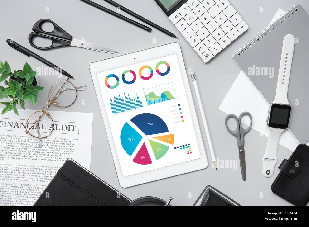 Modern tablet computer with business charts on screen against grey ...