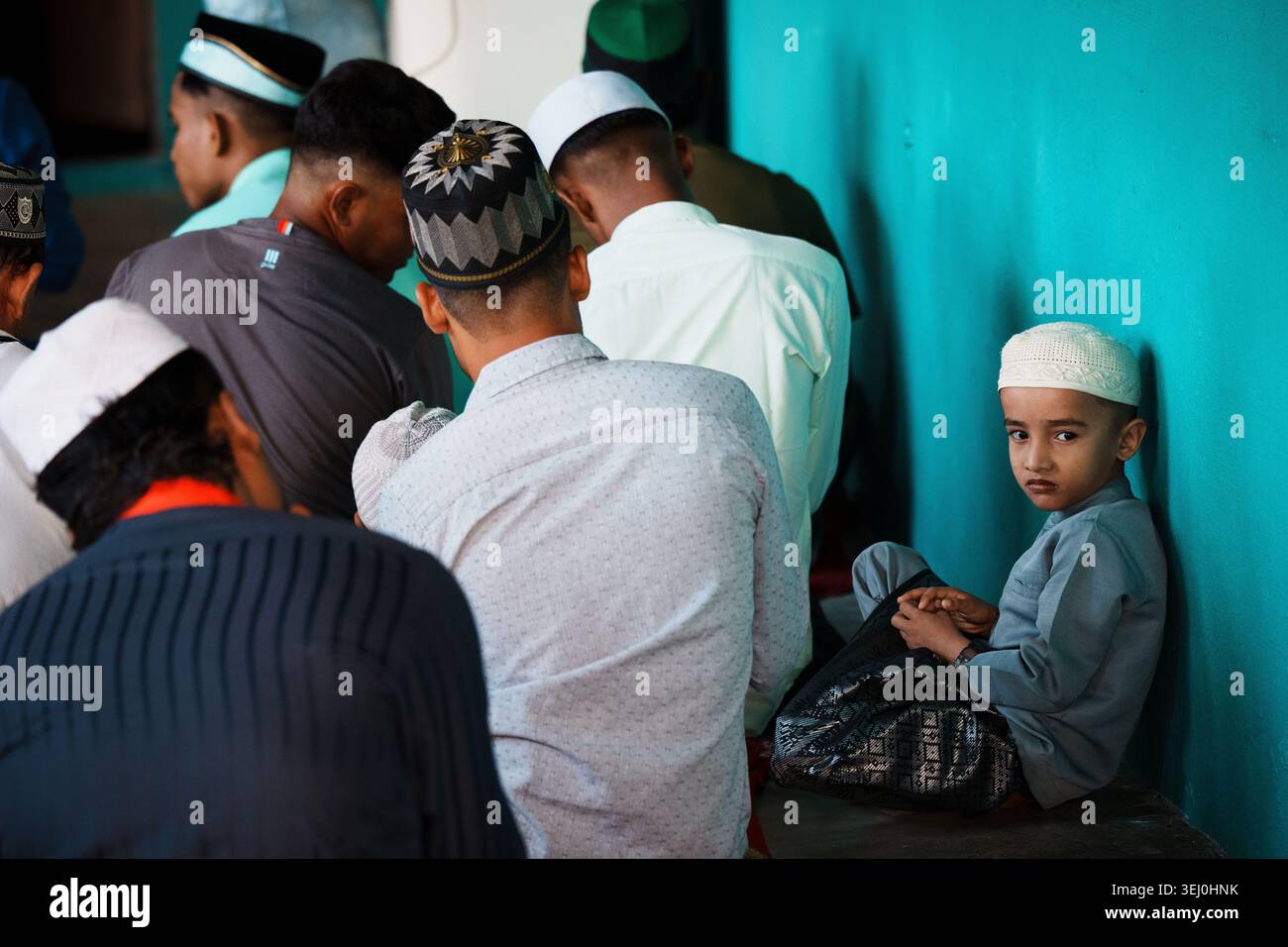 A boy waits for his father to perform morning prayer marking the Eid al ...