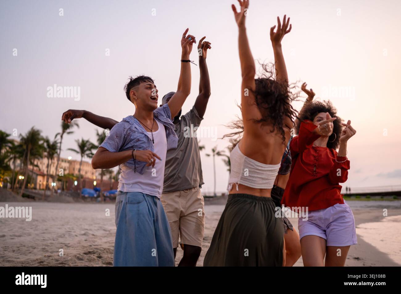 Diverse and multicultural friends dancing on the beach during a summer ...