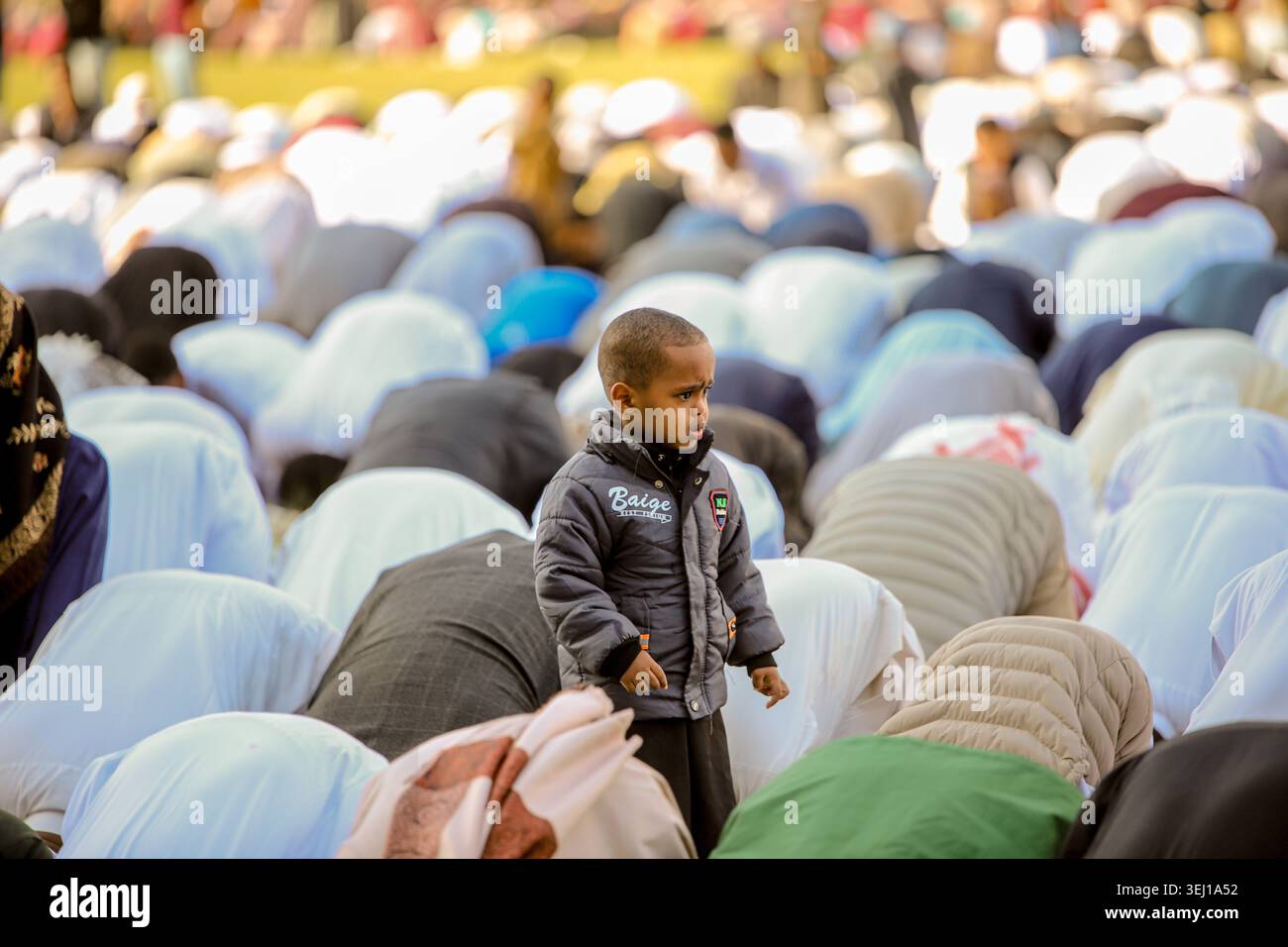 A child walks between a group of Muslim faithful during Eid-al-Adha ...