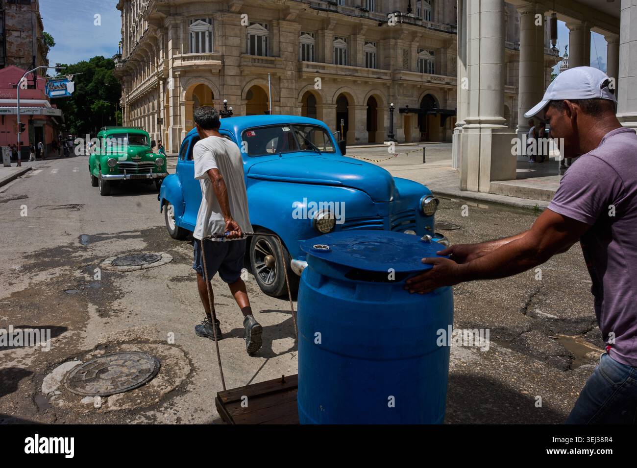 People transport a container of water in Havana, Wednesday, May 27 ...