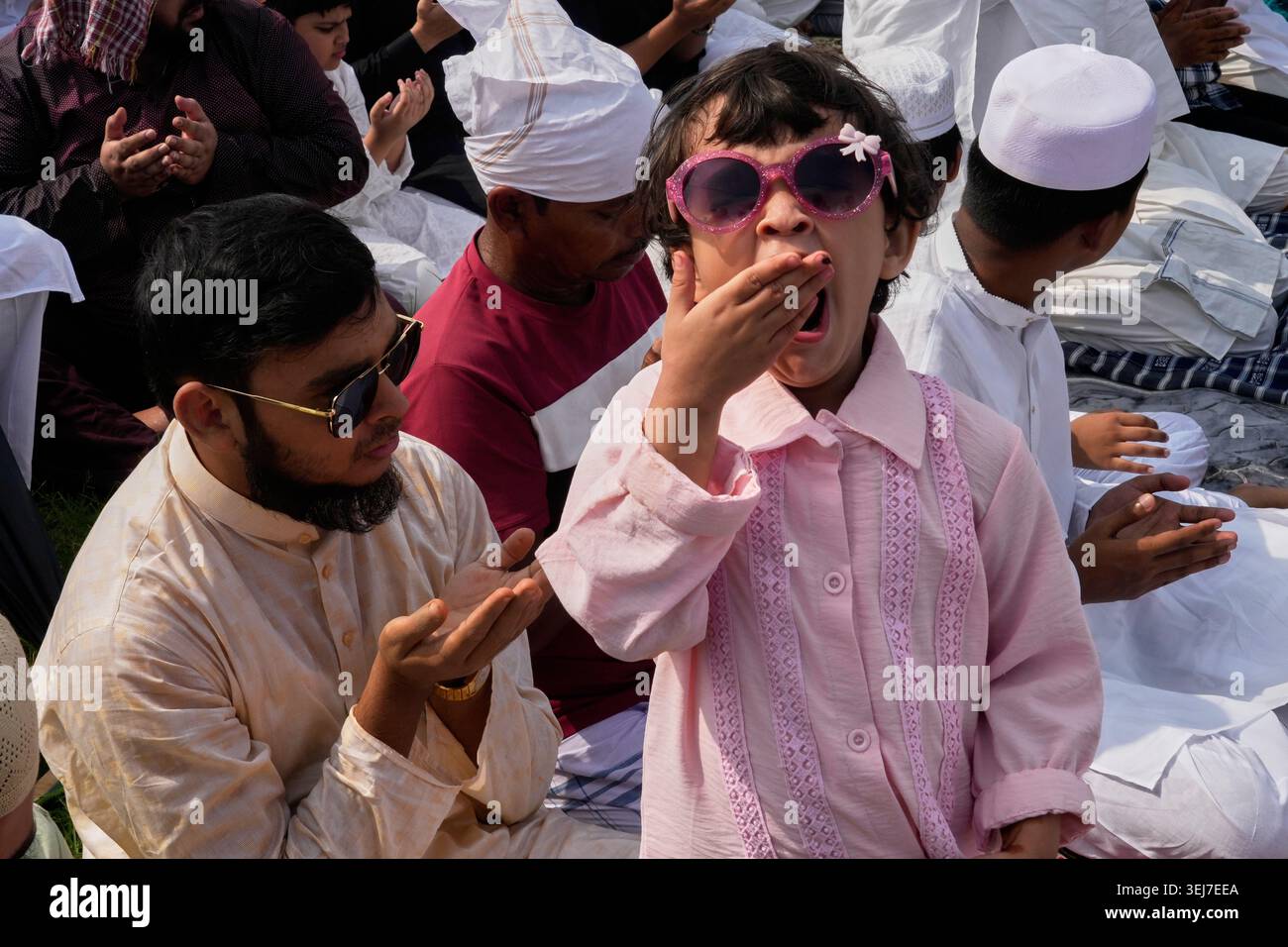 A girl yawns as other Muslims offer Eid al-Adha prayers at Brigade ...