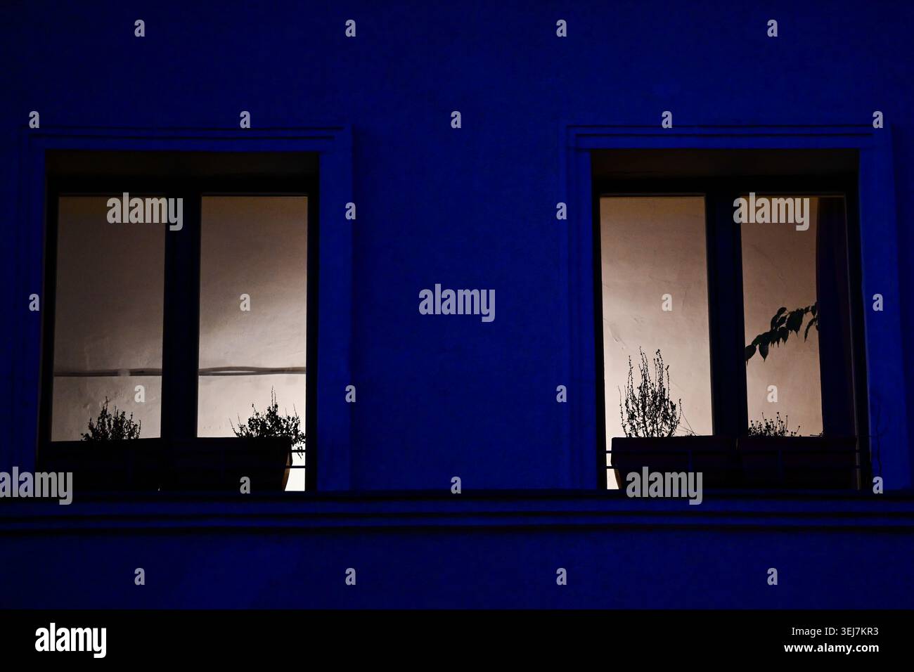 27 May 2026, Berlin: Light shines in apartment windows during the blue ...