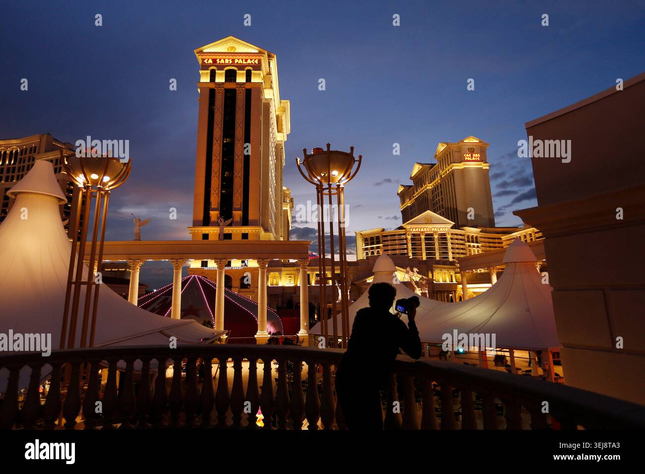 FILE - A man takes pictures of Caesars Palace hotel and casino in Las ...