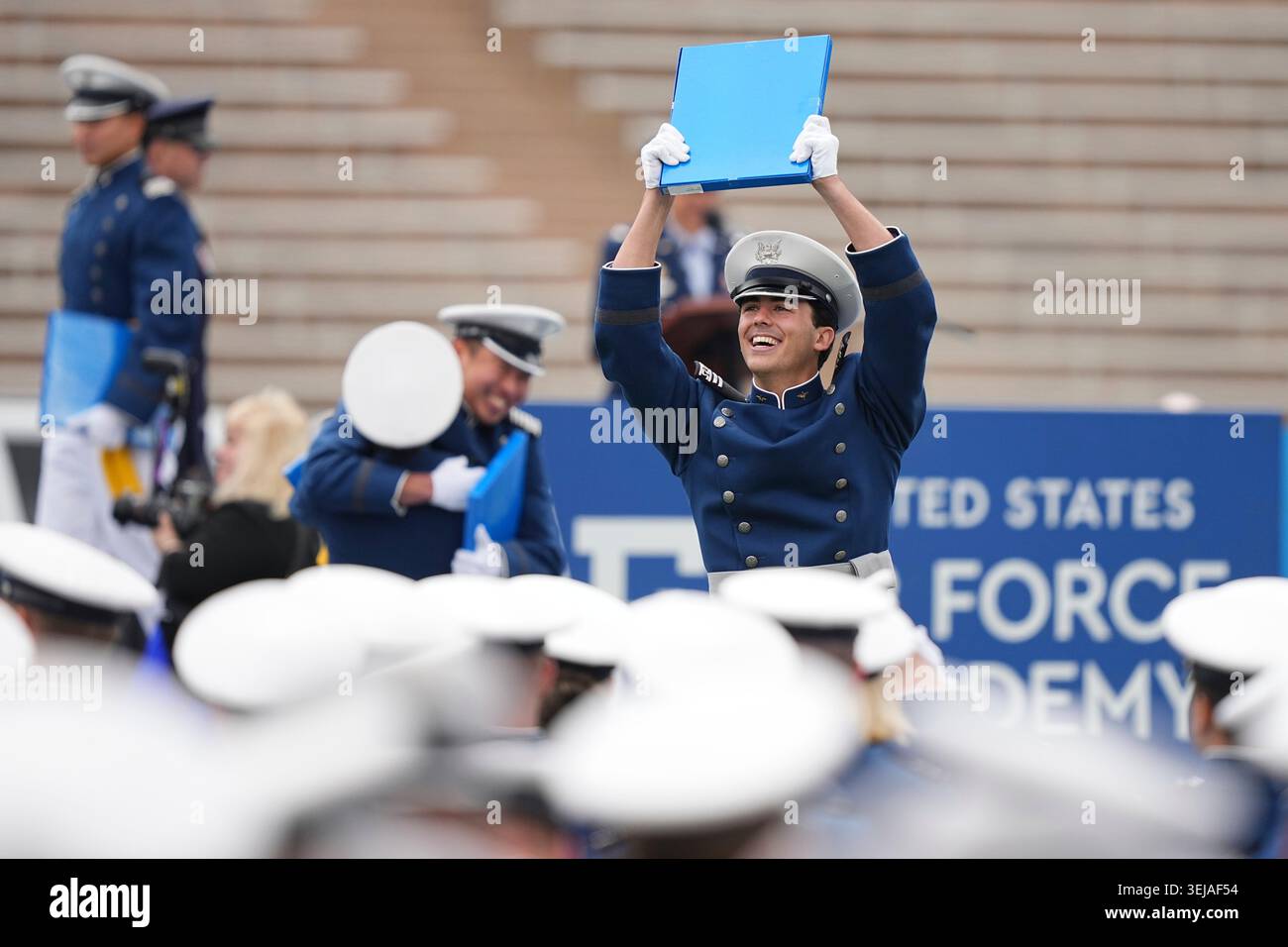 A graduating cadets holds up a diploma during the United States Air ...