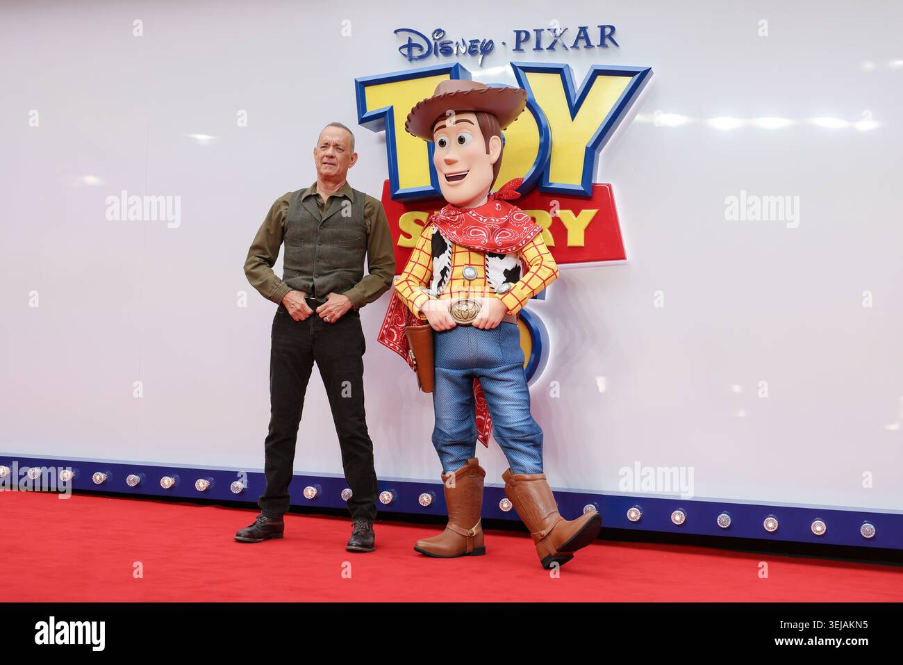 Tom Hanks, left, and a person costumed as the character Woody pose for ...