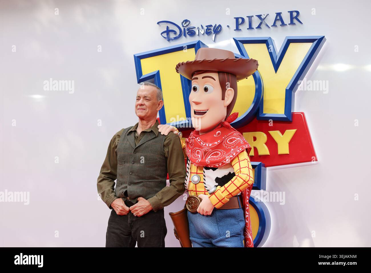 Tom Hanks, left, and a person costumed as the character Woody pose for ...