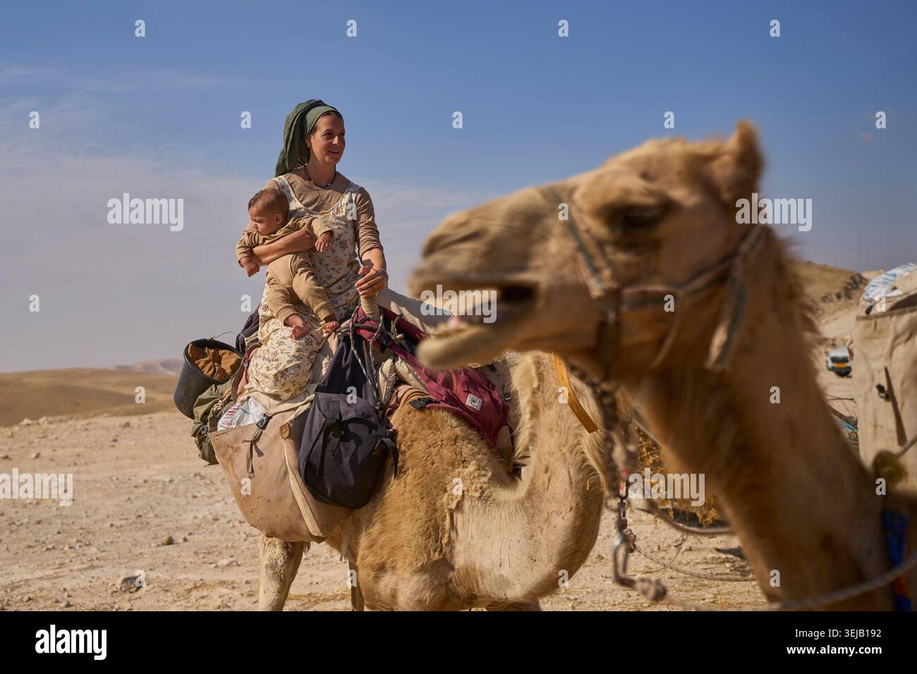 Israeli settler parents travel with their baby on camels in the ...