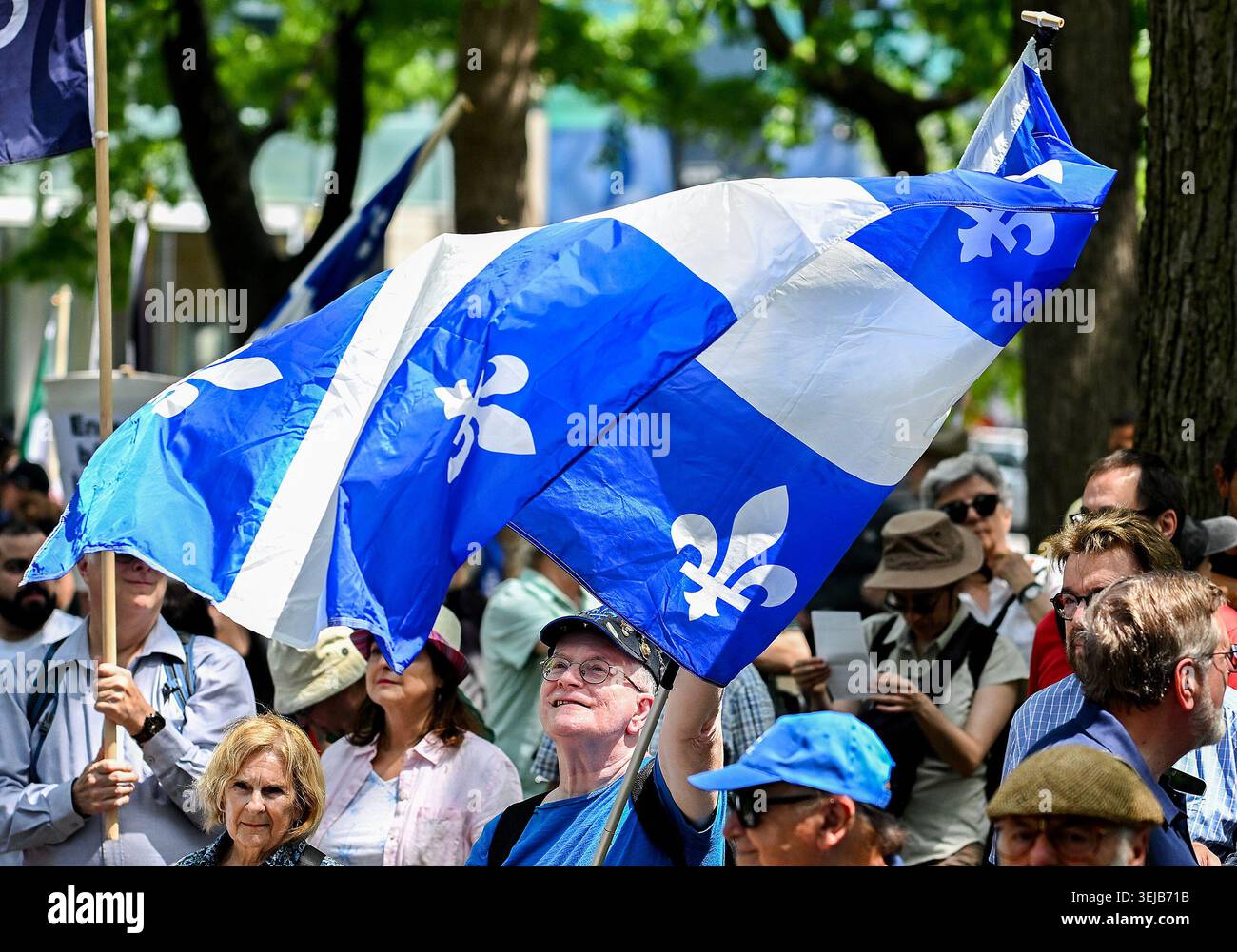 A man waves a Quebec flag during a march to celebrate National Patriots ...