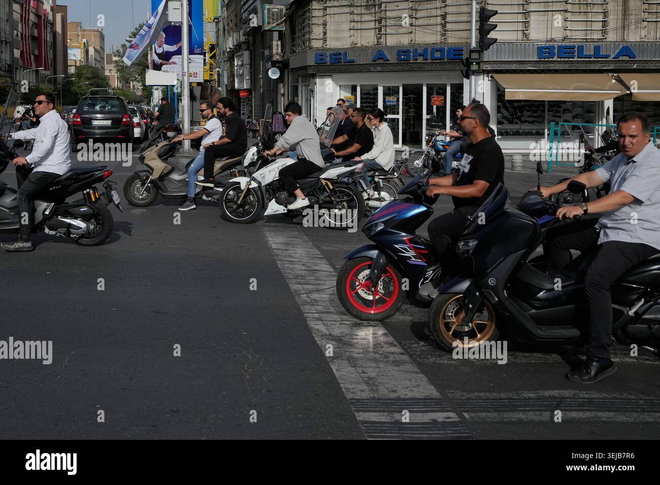 People on the motorbikes wait for the green light to cross an ...