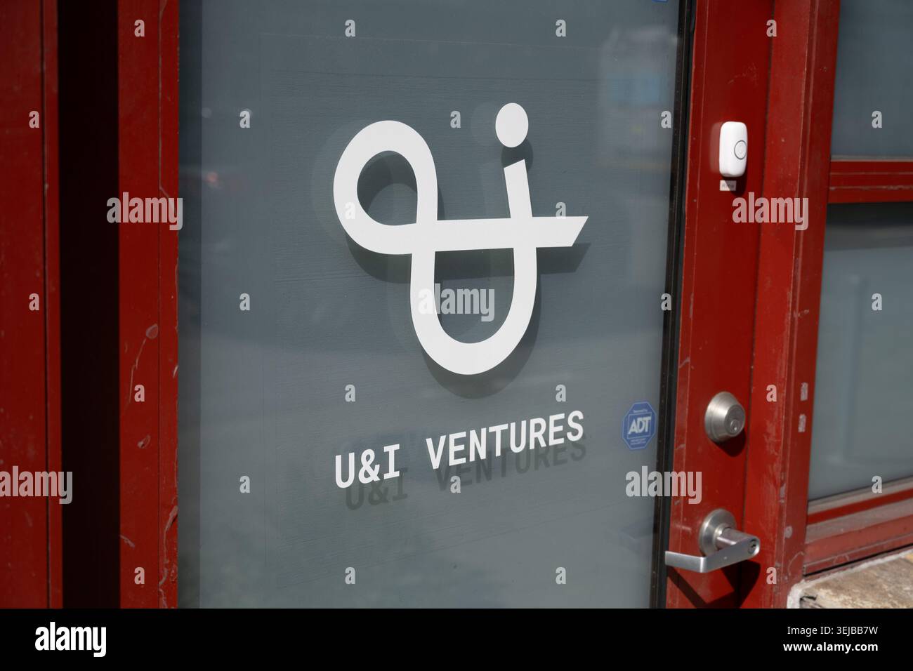 Glass door of a building with U&I Ventures logo and red frame in ...