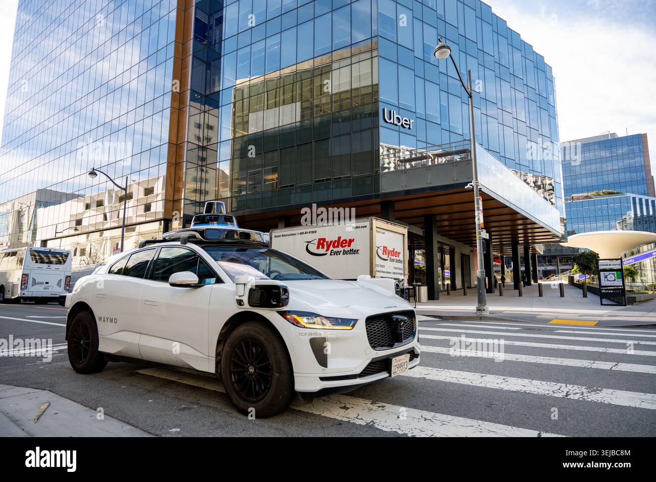 Self-driving Waymo vehicle at city intersection in front of Uber ...