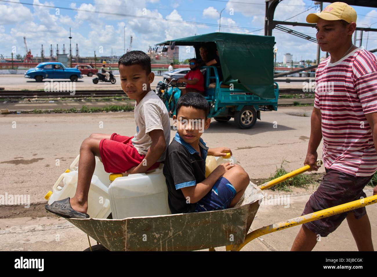 A man transports containers of water with his children in Havana ...