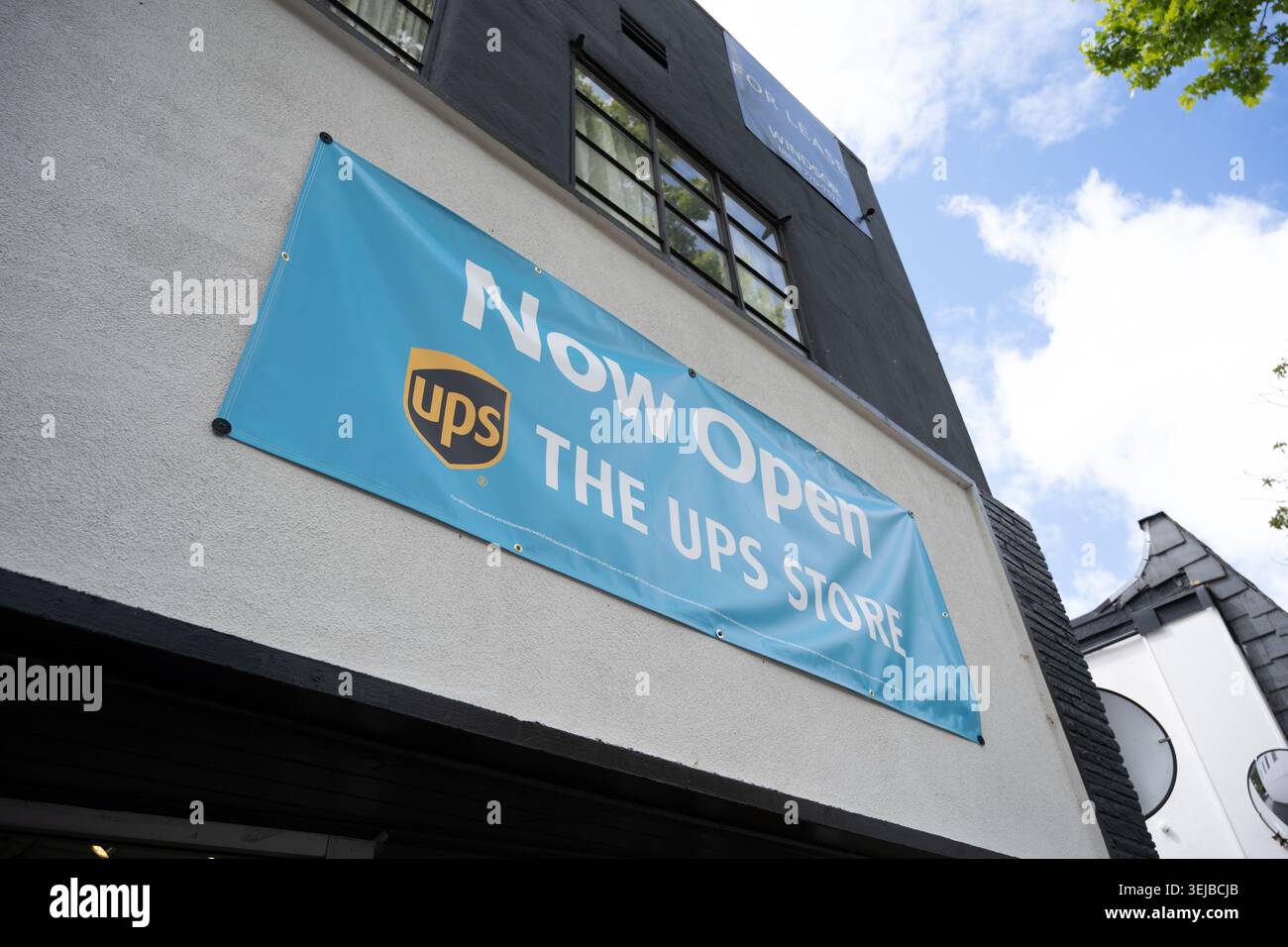 Now Open banner for The UPS Store on exterior of commercial building ...