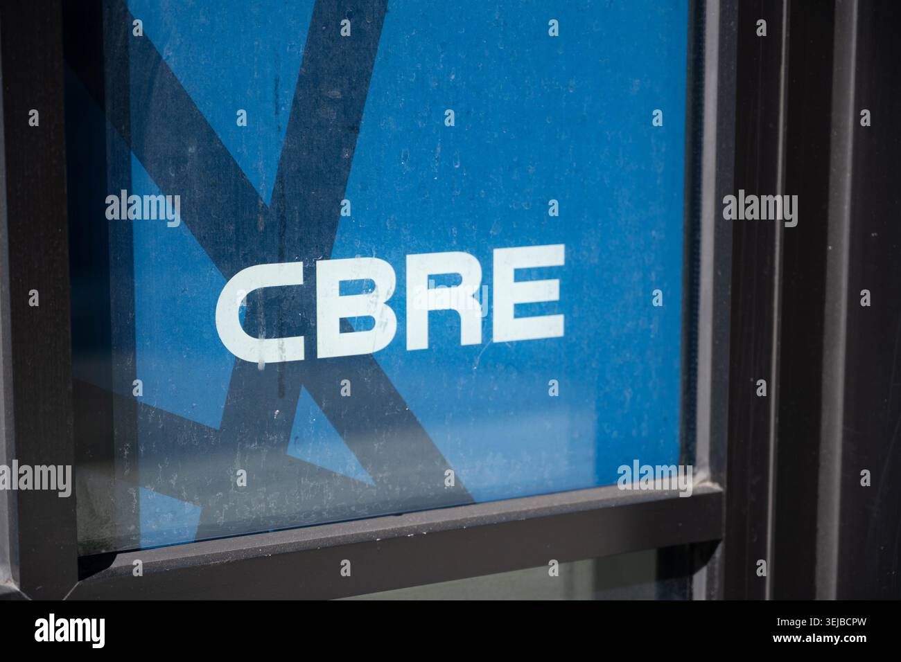 Close-up of CBRE logo on blue sign in window of a building, San ...
