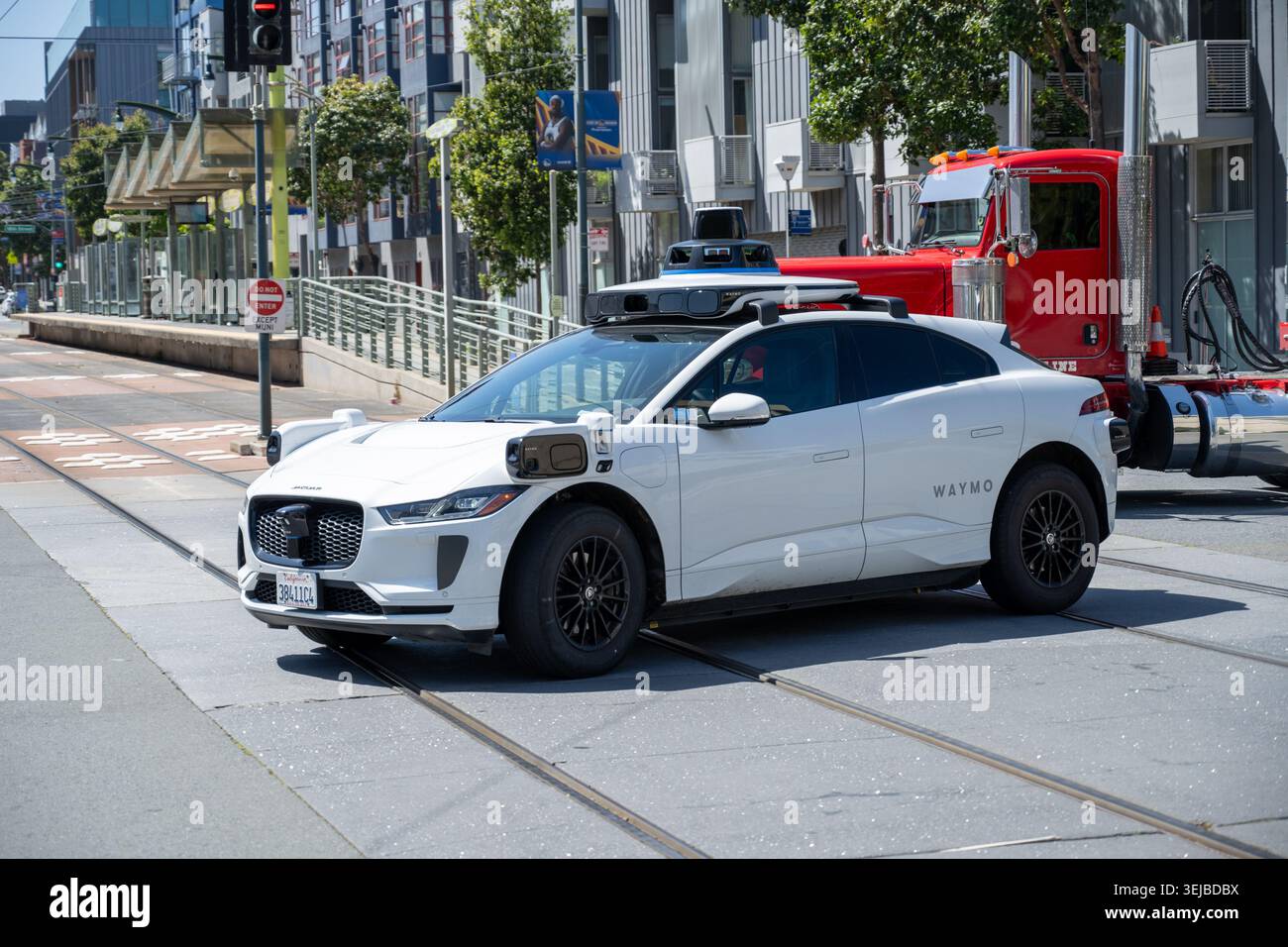 Autonomous Waymo Jaguar I-PACE self-driving car crossing light rail ...