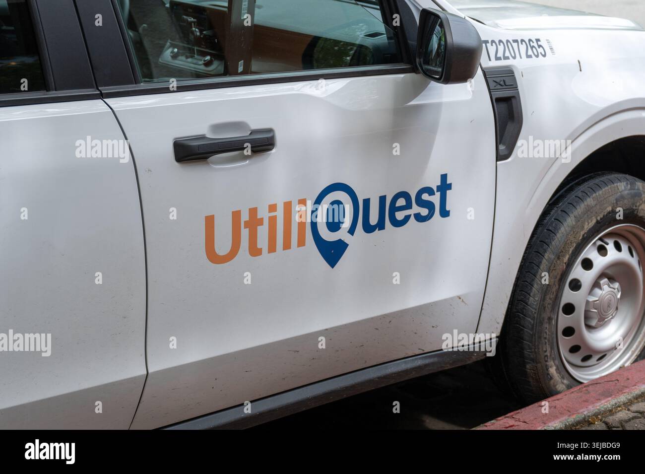 Close-up of UtiliQuest logo on the side of a white work truck parked on ...