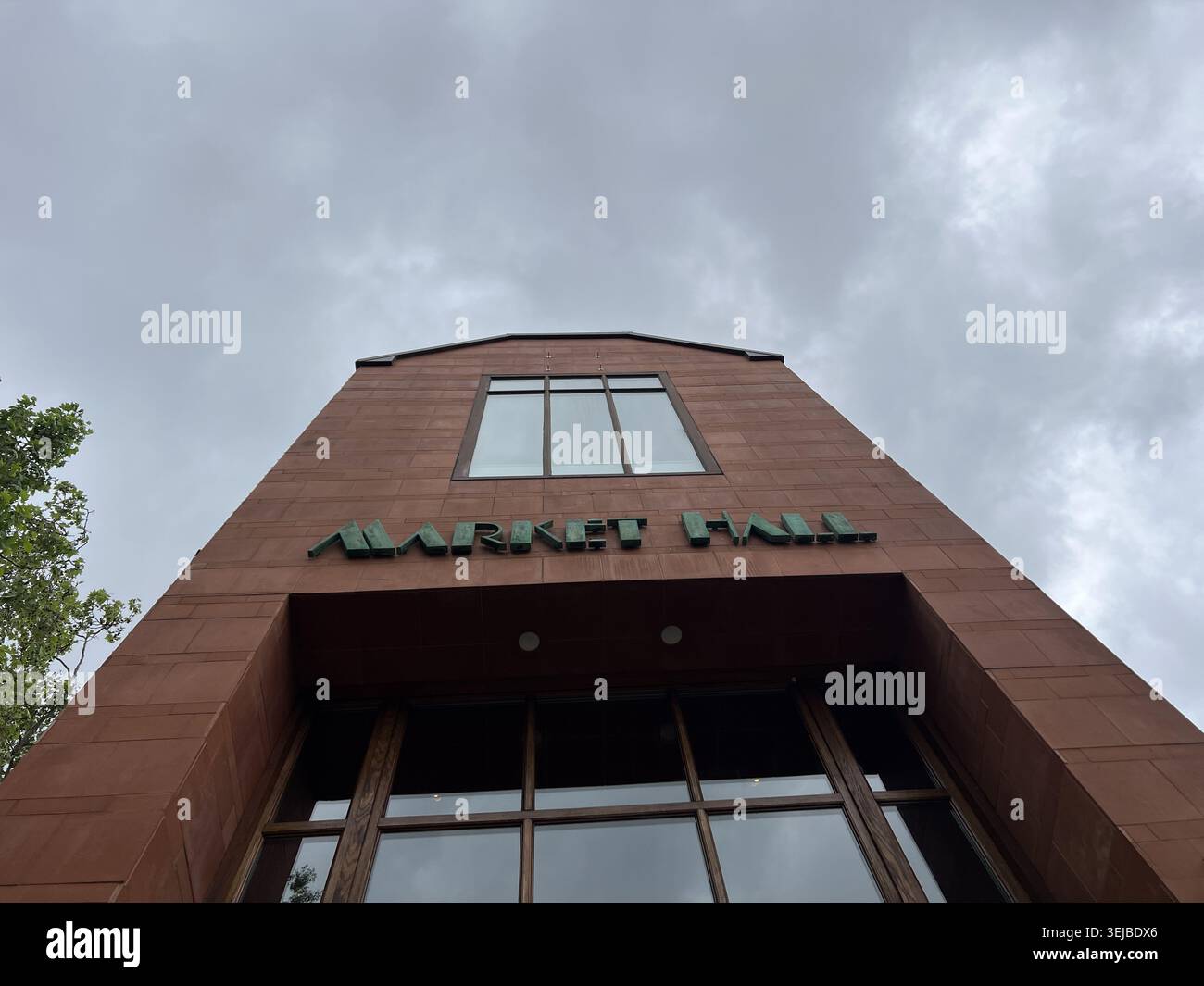 Low-angle view of sign on facade of Market Hall Foods on an overcast ...