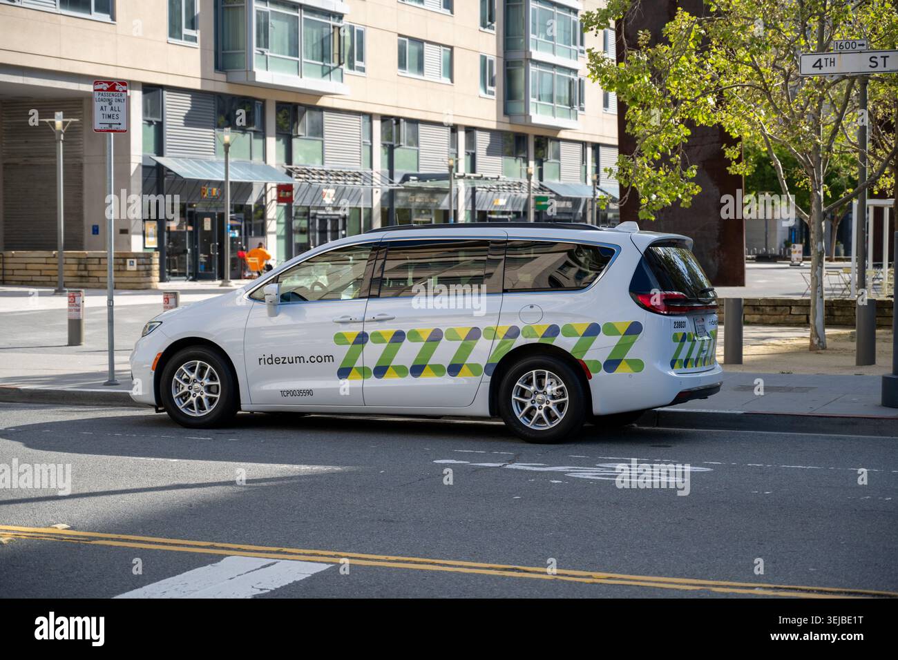 RideZum branded minivan parked on city street near modern apartment ...