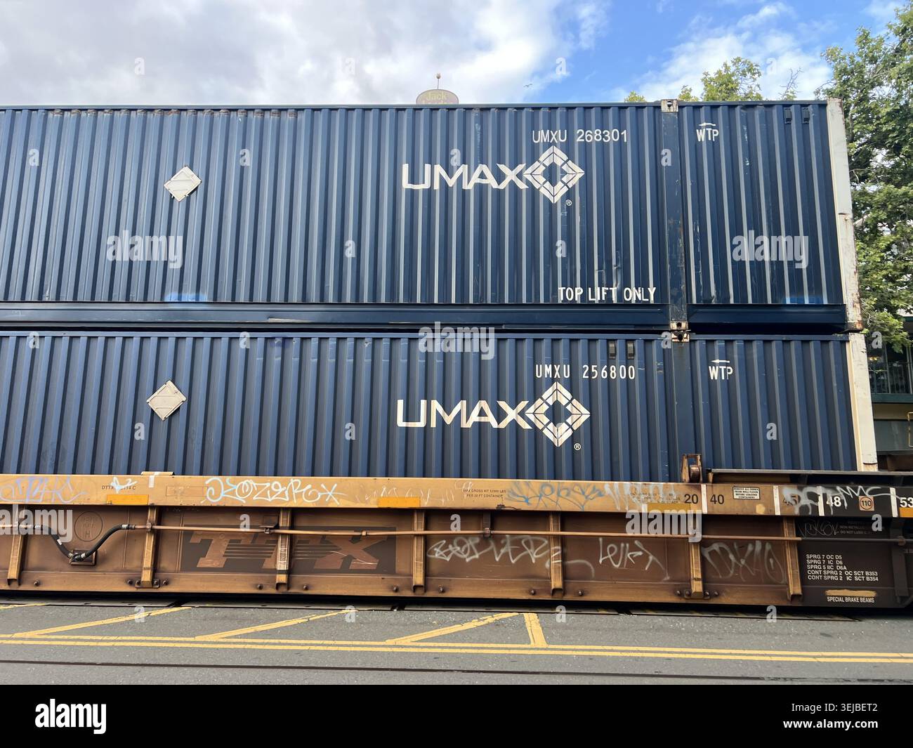 UMAX containers are visible on a freight train traveling past Jack ...