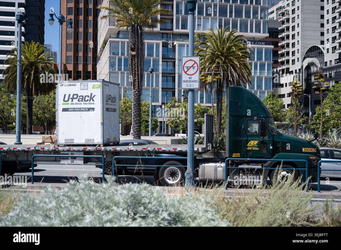 ABF semi truck and U-Pack moving trailer parked on city street with ...