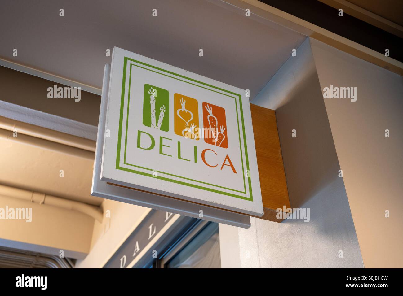 Hanging sign for Delica restaurant with vegetable logo in an indoor ...