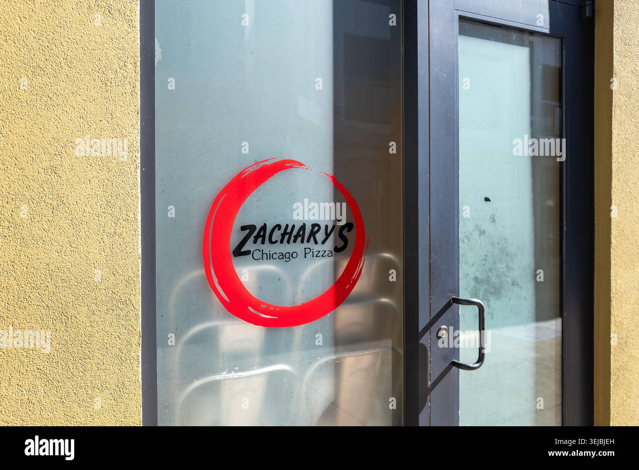 Entrance door with Zacharys Chicago Pizza logo on frosted glass in a ...