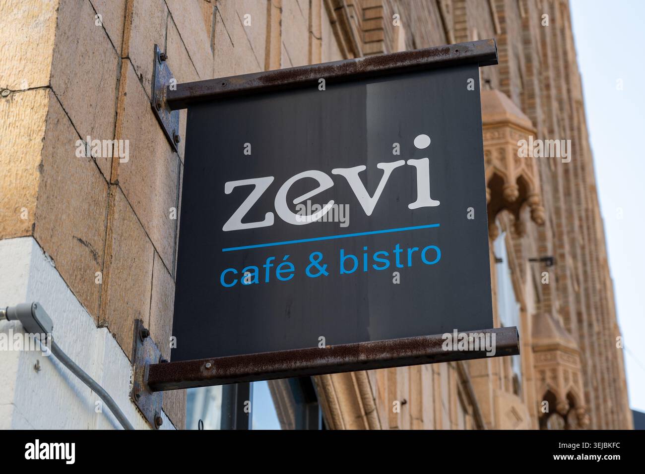 Hanging sign for Zevi Cafe and Bistro on the exterior of a brick ...