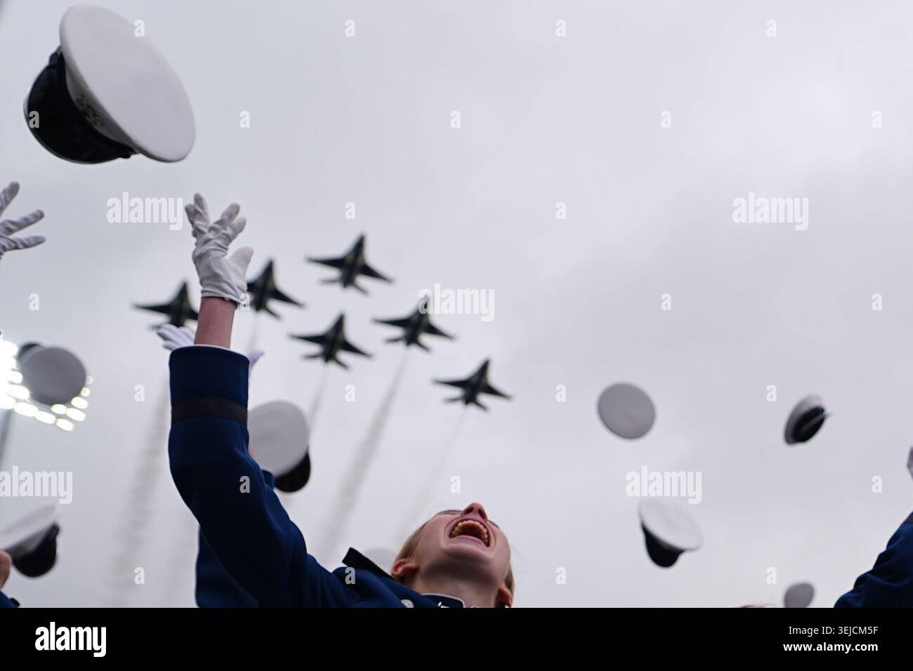 An Air force cadet tosses her hat as the Thunderbirds fly over during ...