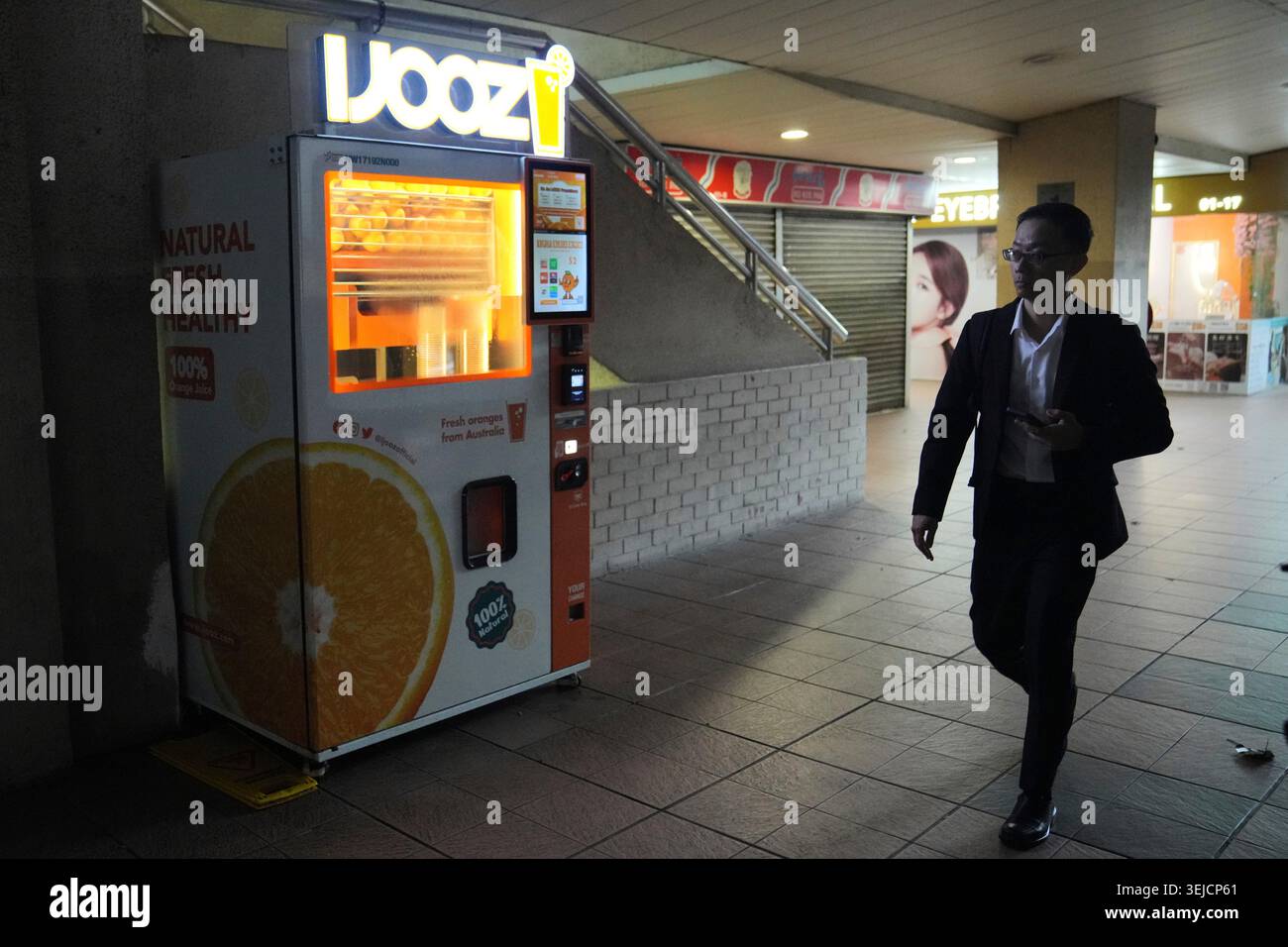 A man walks past an Ijooz orange juice vending machine in Singapore ...
