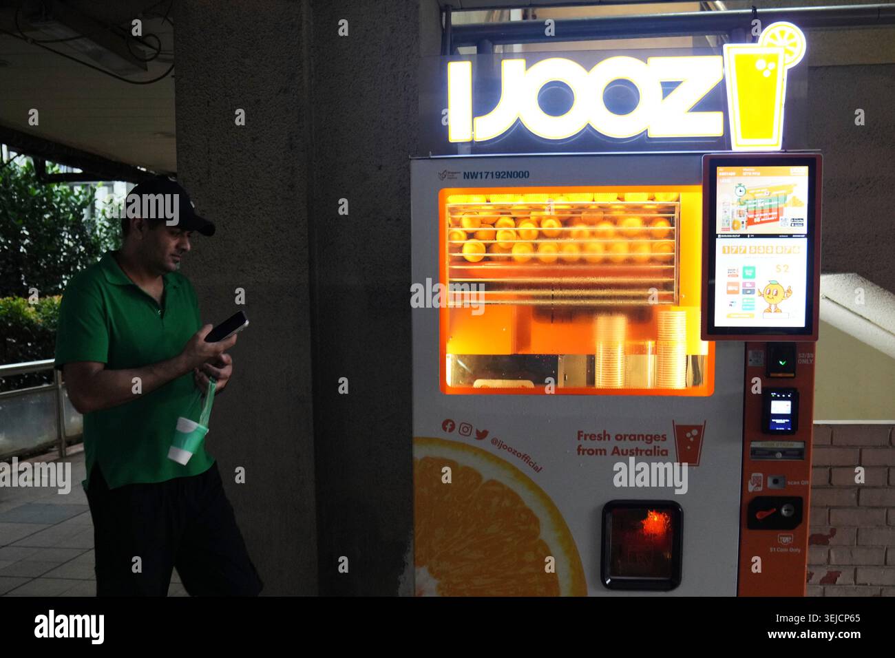 A man walks past an Ijooz orange juice vending machine in Singapore ...