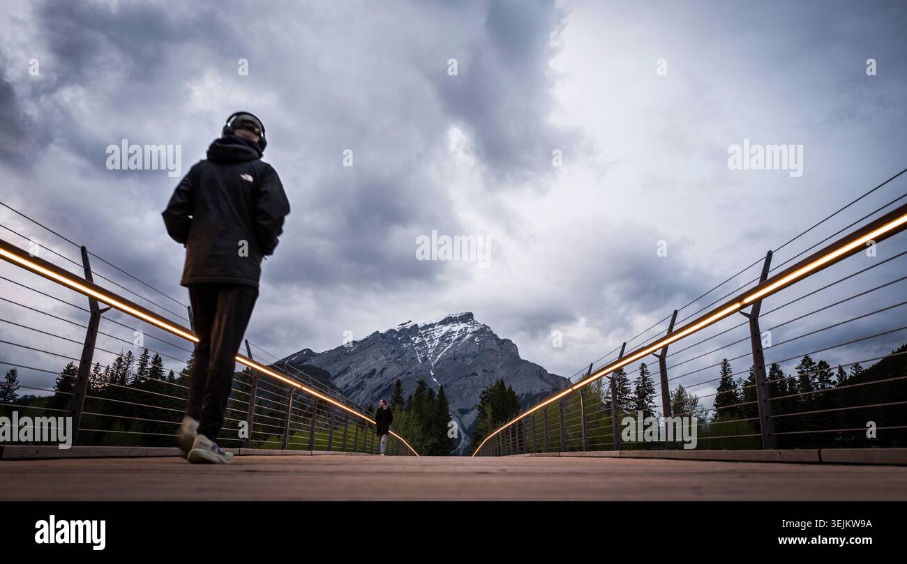 A pedestrian cross a bridge over the Bow River in Banff, Alta., Tuesday ...