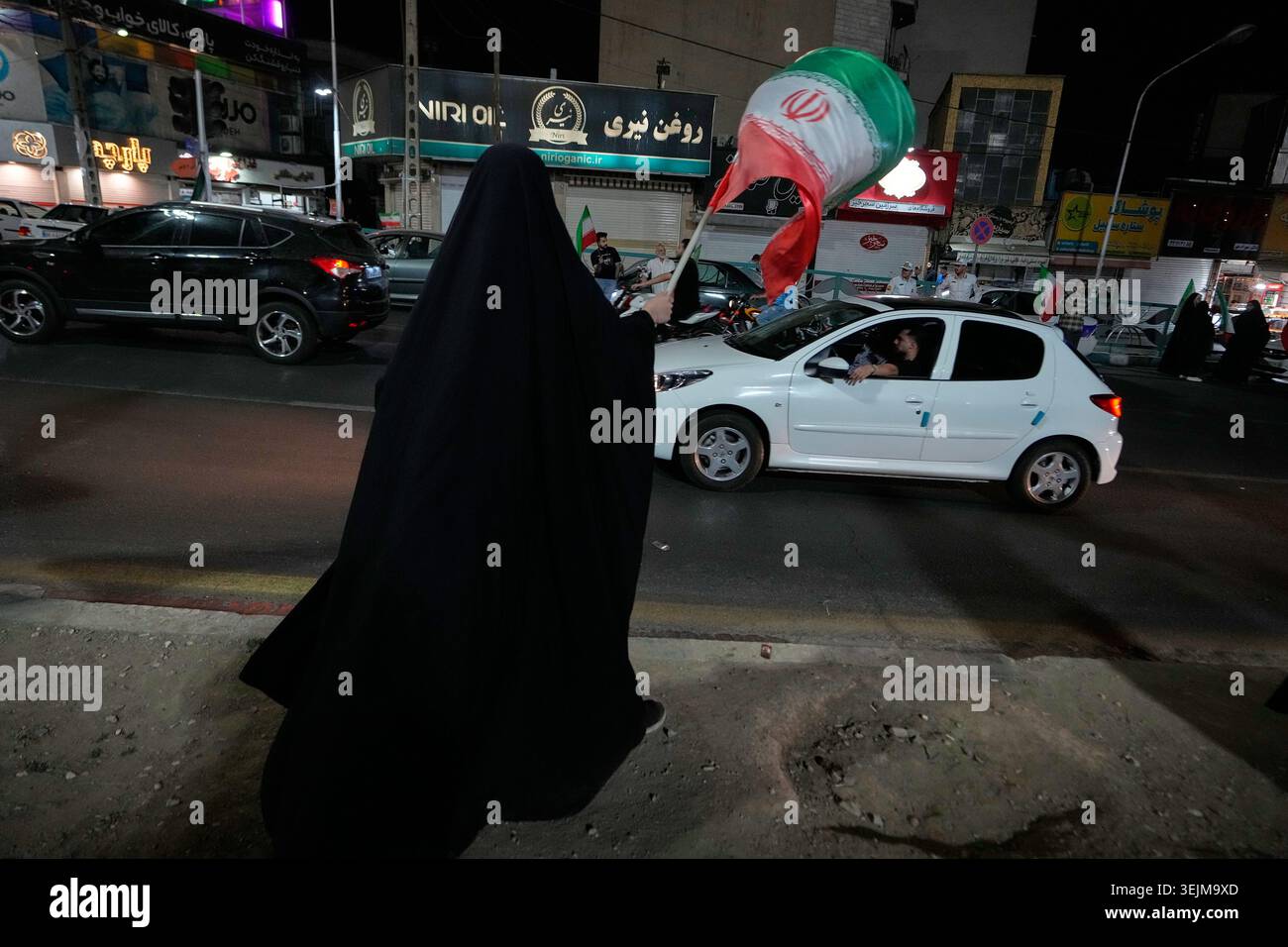 A woman waves an Iranian flag in a pro-government gathering at a square ...