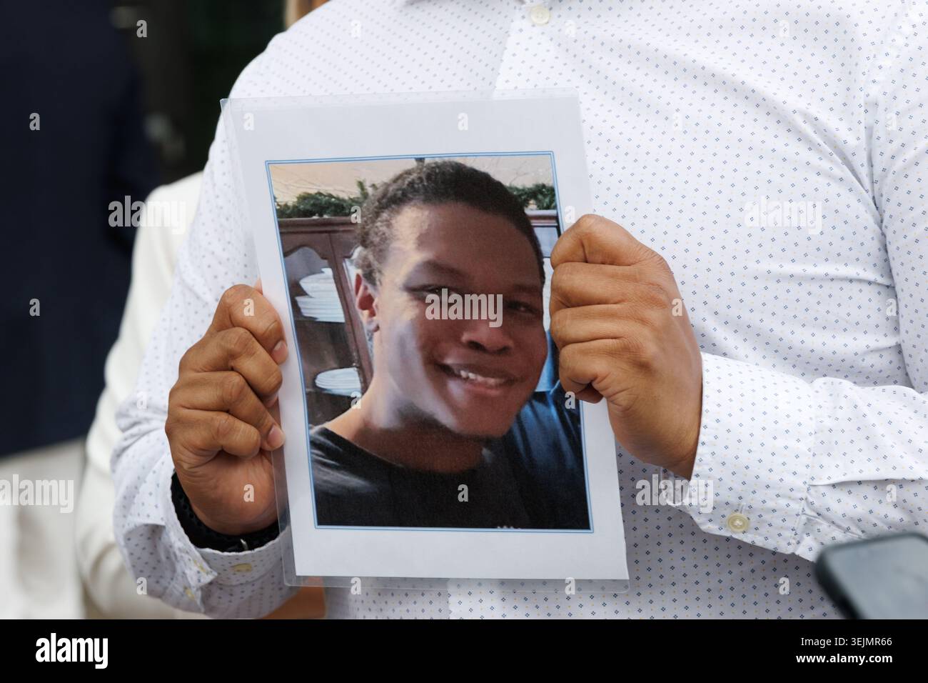 Ethan Mitchell holds a photograph of his brother, Stephen Jr., outside ...