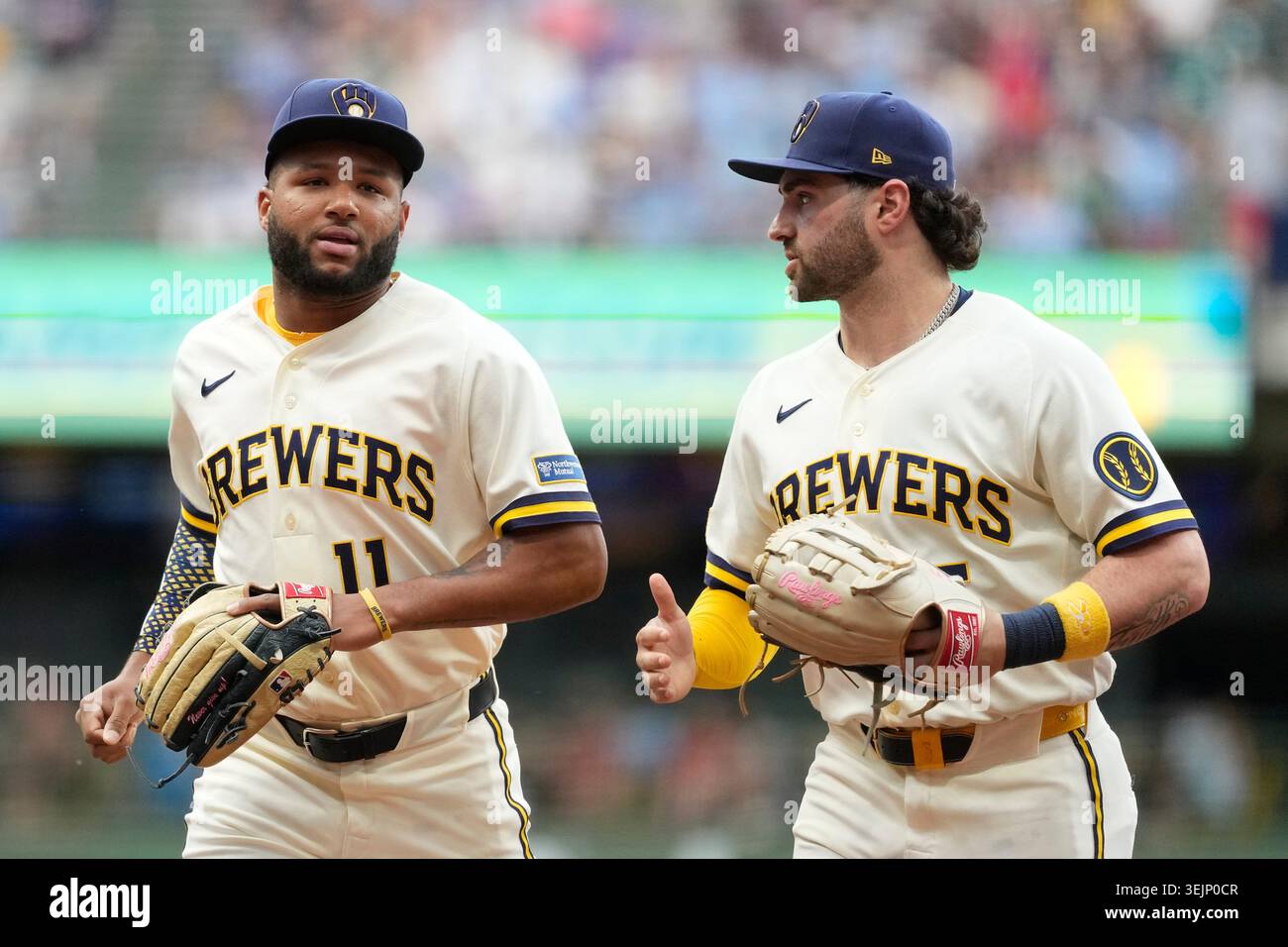 Milwaukee Brewers' Jackson Chourio talks with Garrett Mitchell during a ...