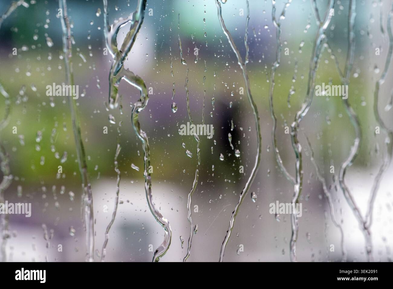 31 May 2026, Bavaria, Herzogenaurach: Rainwater runs down a window pane ...