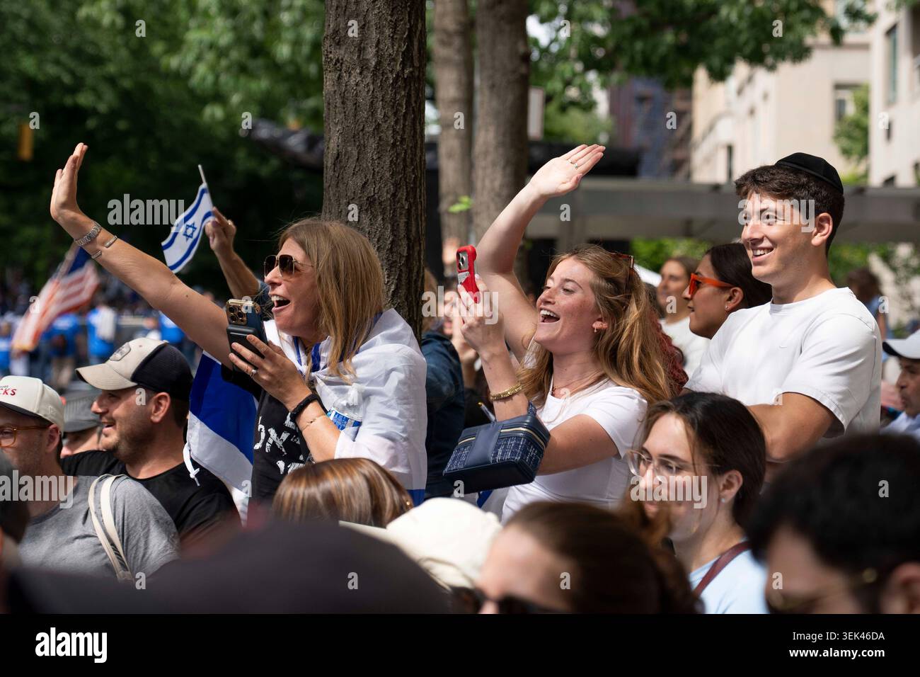 Spectators wave at parade participants during the Israel Day Parade ...