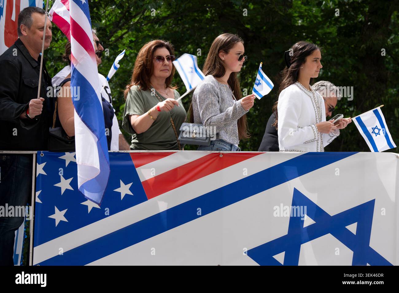 Parade participants wave flags at spectators during the Israel Day ...