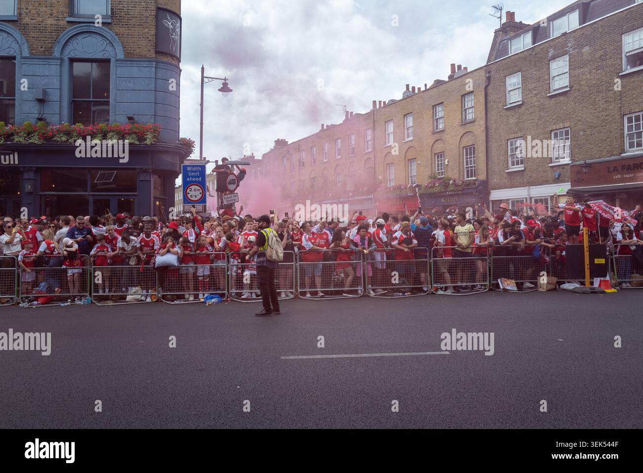 Arsenal fans celebrate on the side of the street as they wait for the ...