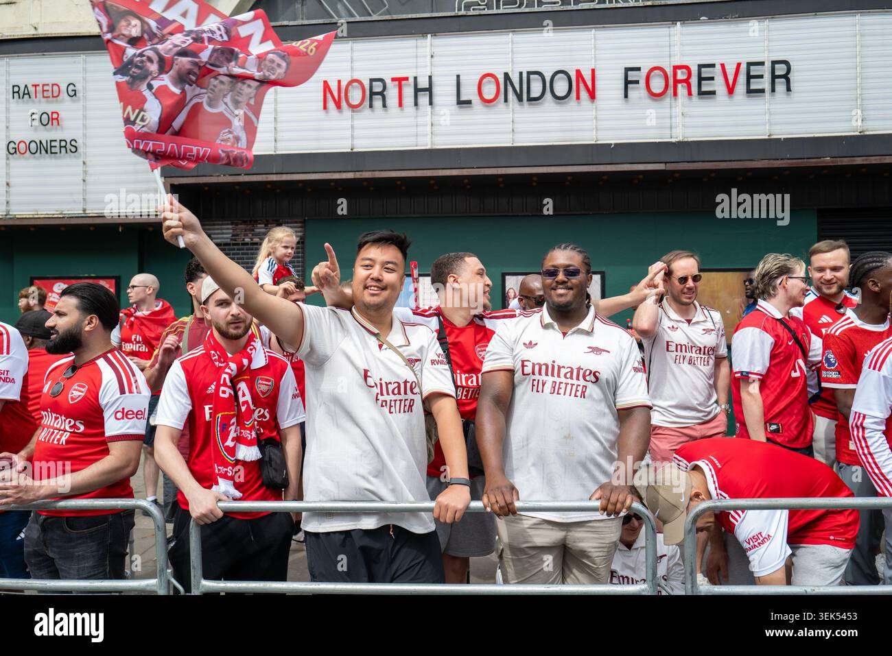 Arsenal fans celebrate on the side of the street as they wait for the ...