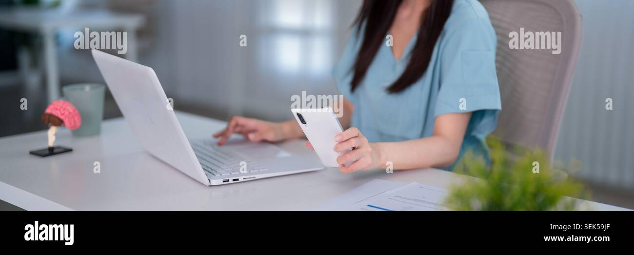Asian doctor using laptop computer and smartphone for online ...