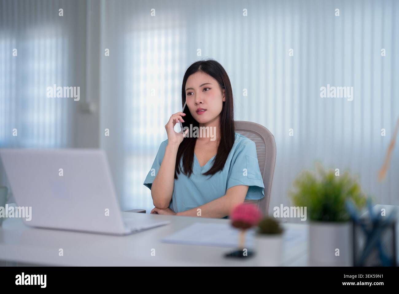 Asian young woman professional speaking on smartphone while using ...