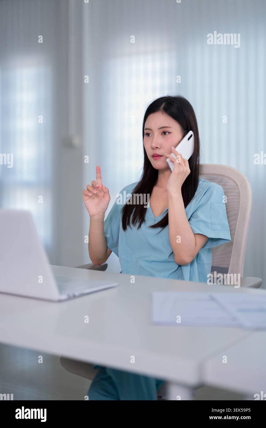 Asian female doctor making phone call with hand gesture explaining ...