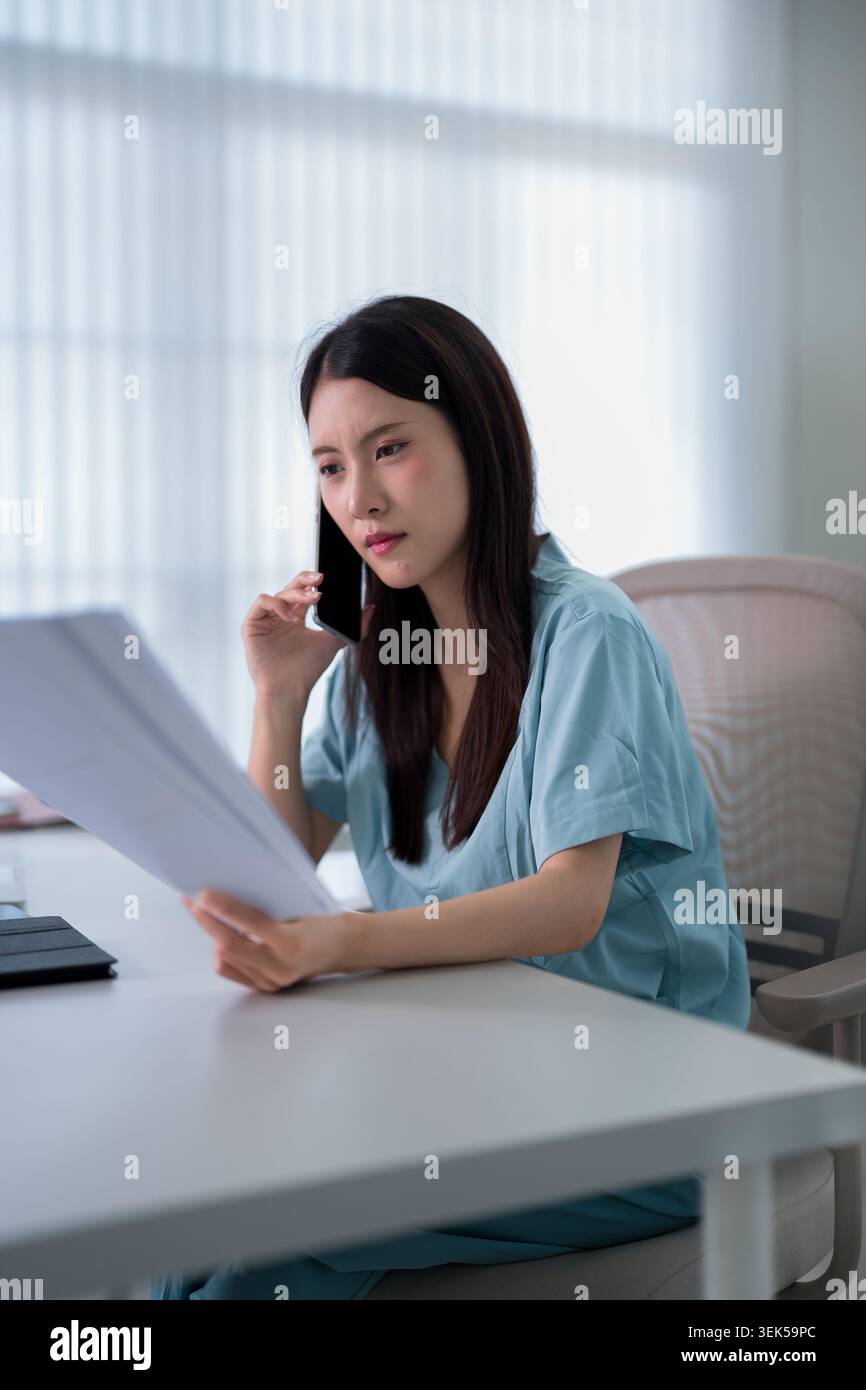 Young Asian female healthcare worker medical professional making phone ...