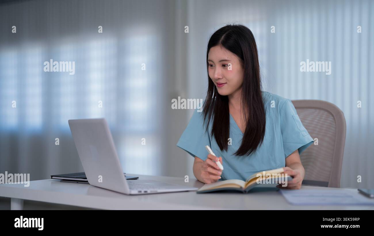 Asian woman doctor writing medical notes in notebook studying with ...