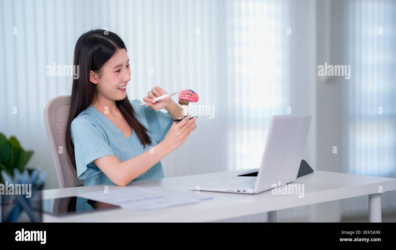 Young Asian female doctor examining anatomical brain model during ...