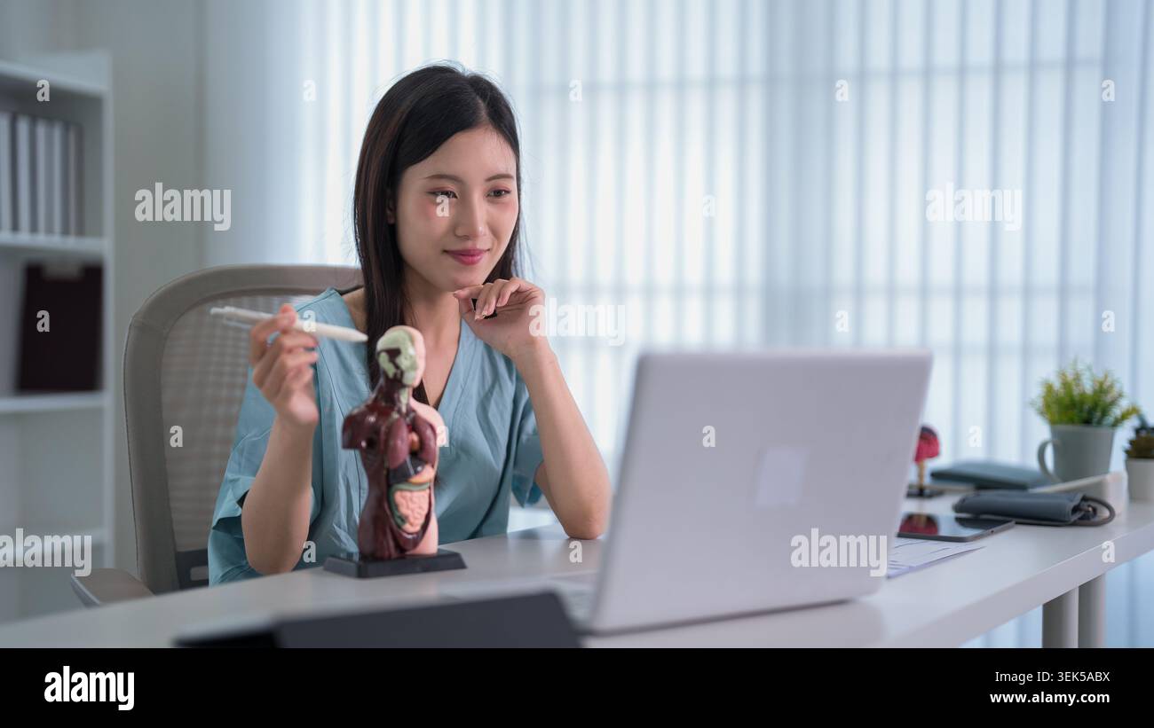 Asian woman medical professional teaching anatomy using laptop for ...