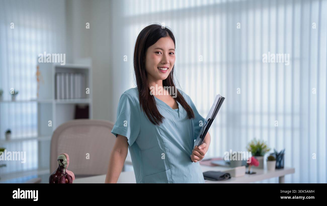 Young Asian medical professional with tablet in bright modern office ...
