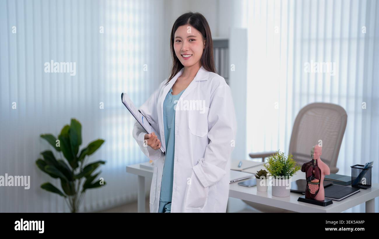 young Asian woman doctor hold clipboard smile at modern medical clinic ...