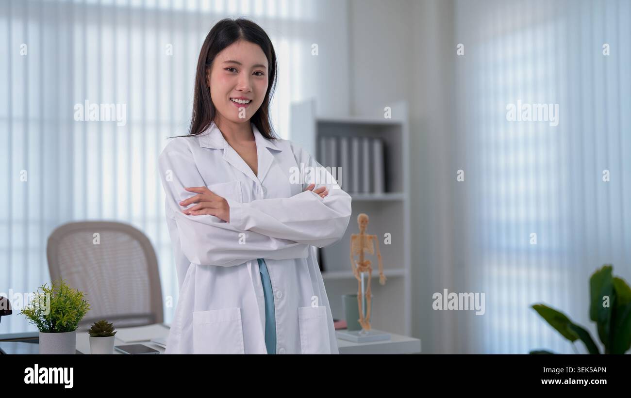 young asian woman doctor in white lab coat standing confident with arms ...